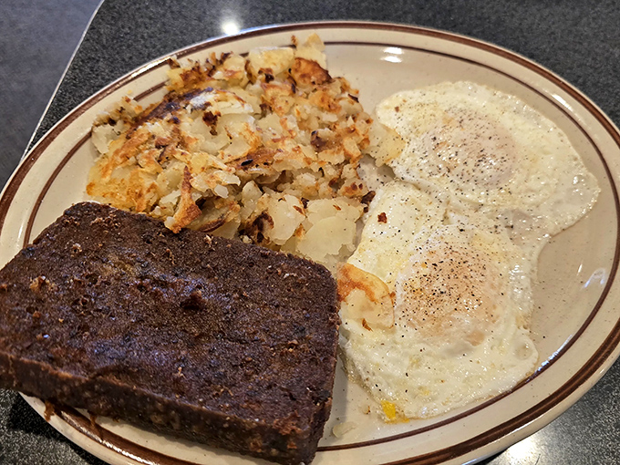 The holy trinity of breakfast: perfectly fried eggs, crispy hash browns, and scrapple &ndash; Delaware's contribution to morning happiness. Pure comfort on a plate.