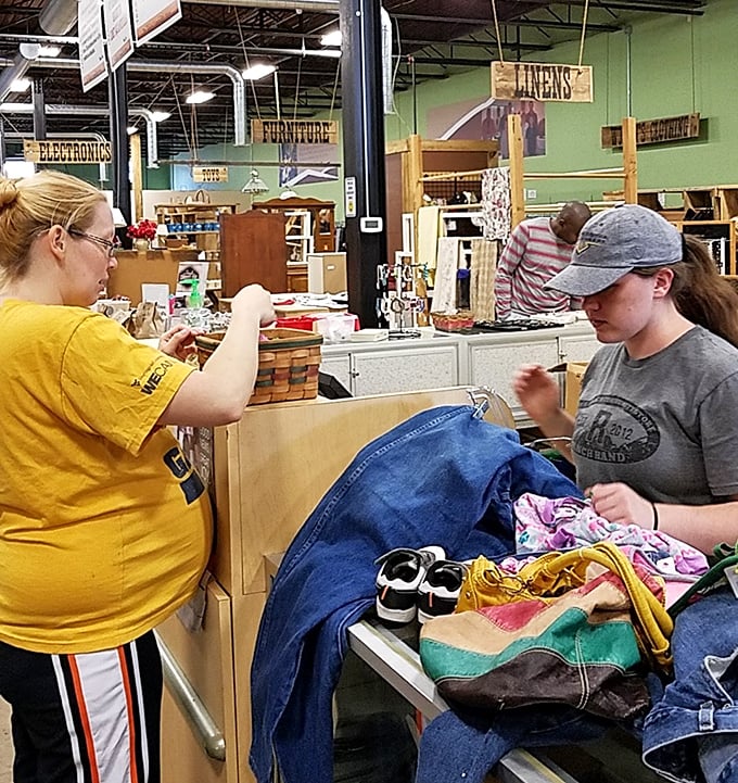 The thrill of the hunt captured in real-time—shoppers evaluating potential treasures with the serious concentration of diamond appraisers.