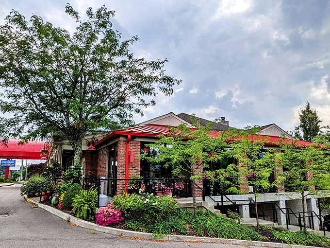 Lush greenery and colorful flowers frame the entrance, proving they care about first impressions as much as they care about their chicken.