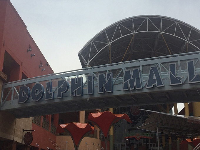 The iconic Dolphin Mall sign stands as a beacon for bargain hunters—like the North Star for shoppers.