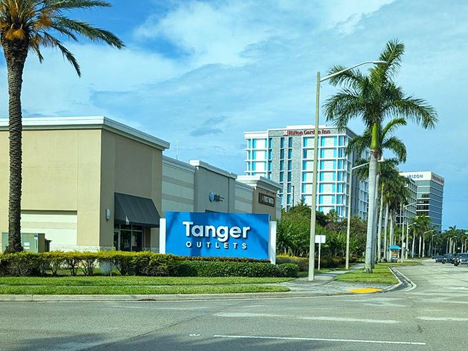 The iconic blue Tanger sign stands as a beacon of hope for fashionistas on a budget against Florida's perpetually sunny skies.