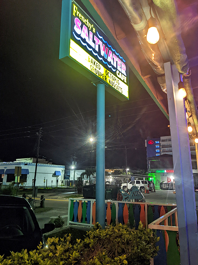 As night falls, the Frenchy's sign glows like a lighthouse for hungry travelers seeking authentic Gulf Coast treasures.