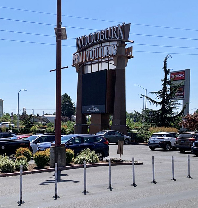 The Woodburn Premium Outlets sign stands tall against Oregon's blue sky, a beacon of retail promise visible from Interstate 5.