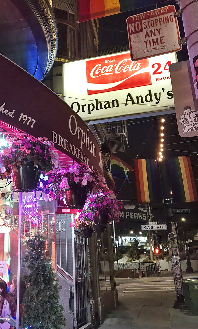 By night, the neon glow of Orphan Andy's sign serves as a lighthouse for hungry souls navigating the Castro's vibrant streets. 