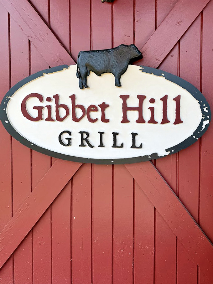 The Gibbet Hill sign on classic barn-red doors&mdash;a beacon for hungry travelers seeking authentic farm-to-table dining in Massachusetts countryside.