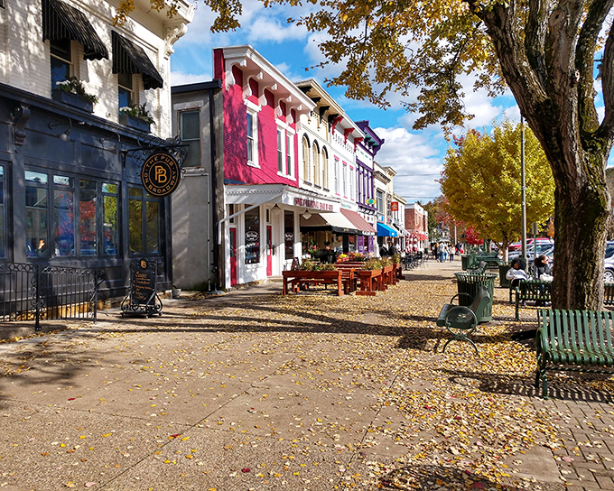 Fallen leaves carpet the sidewalk beneath vibrant storefronts, creating a runway of gold for shoppers exploring Granville's charming commercial district.