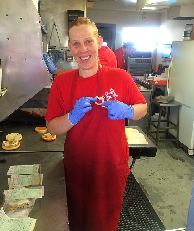 The smile says it all—this isn't just a job, it's a calling. Creating happiness one perfectly formed patty at a time.