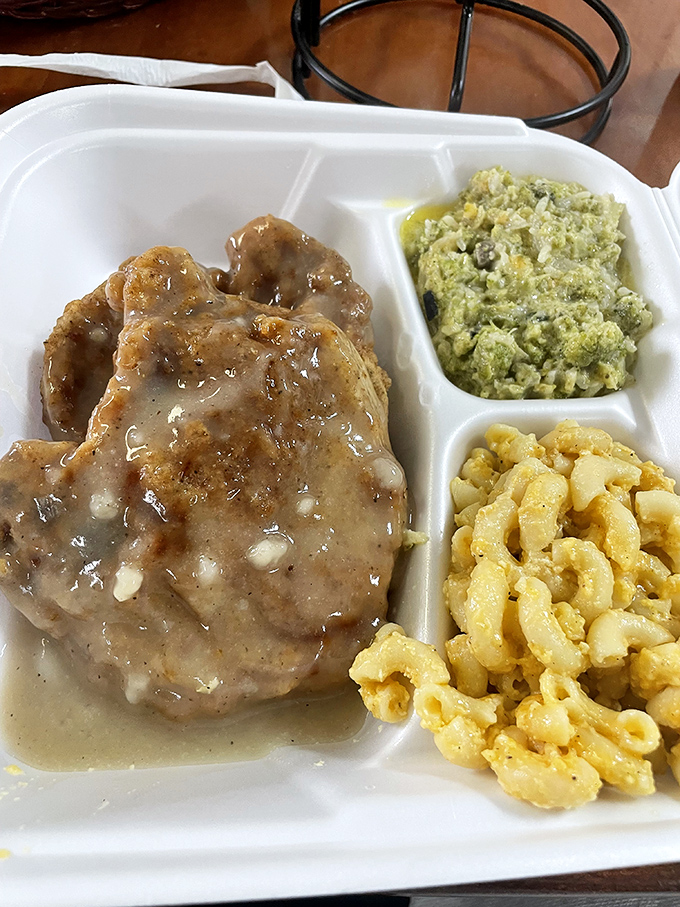 Smothered pork chop swimming in gravy alongside mac and cheese and broccoli casserole. Diet plans come here to die happy deaths.