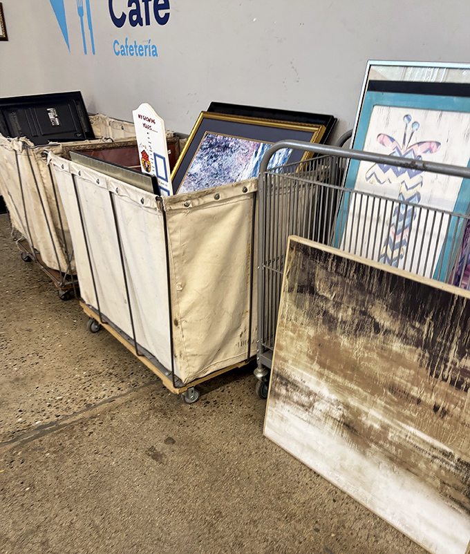 Industrial laundry carts filled with framed artwork. These canvas and frame orphans are just waiting for someone to say, "That would look perfect above my couch."