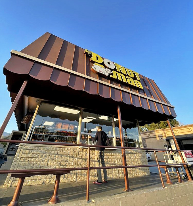 Morning sunshine illuminates the donut promised land. That distinctive brown roof has sheltered generations of sweet-toothed pilgrims seeking sugary salvation.