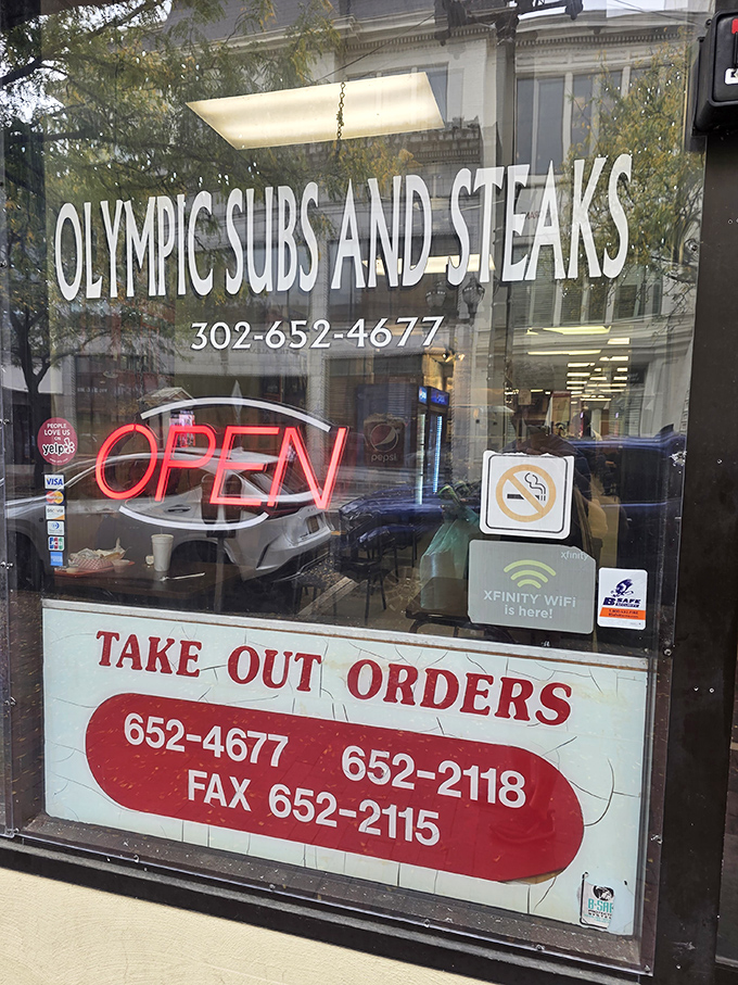 The storefront window proudly displays its contact info&mdash;because when cheesesteak cravings strike, you need to know who to call.