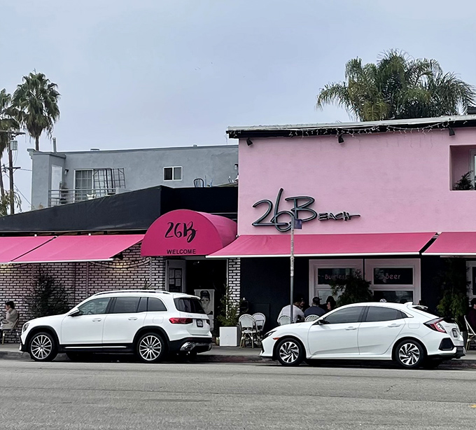 The pink building with its signature awning stands ready for another day of culinary adventures. Cars line up outside&mdash;locals know where the good stuff is.