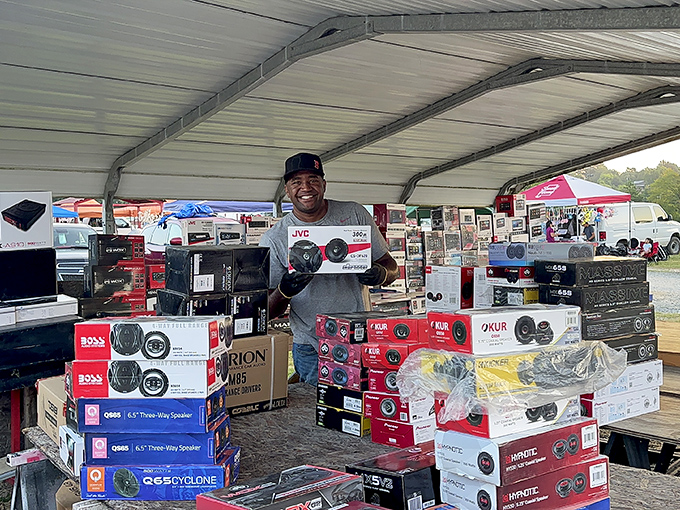 A vendor's pride shines brighter than his merchandise&mdash;that smile says he knows exactly what audio treasures he's offering.