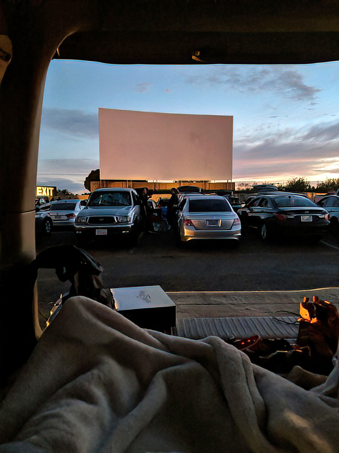 The perfect drive-in view: blank screen awaiting cinematic magic, framed by your dashboard and the comfort of your own vehicle.