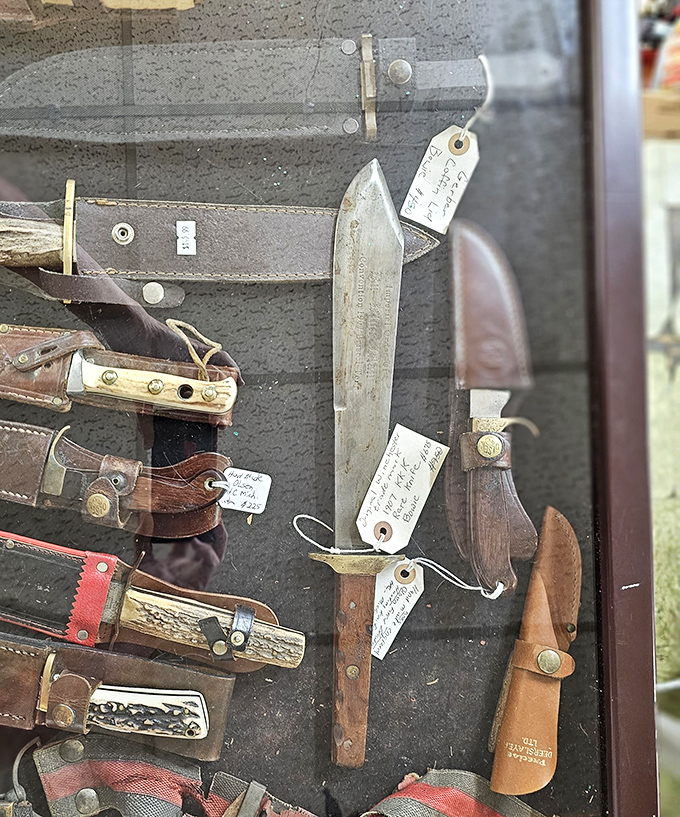Behind glass, vintage knives and hunting implements rest in dignified display. Each blade carries the patina of adventures from another era.