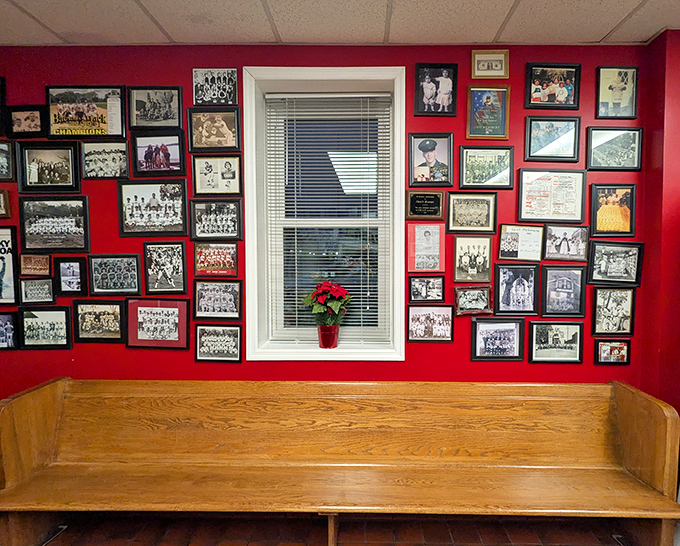 A red wall covered in photographs tells decades of stories while you wait for your order in wooden booth comfort.