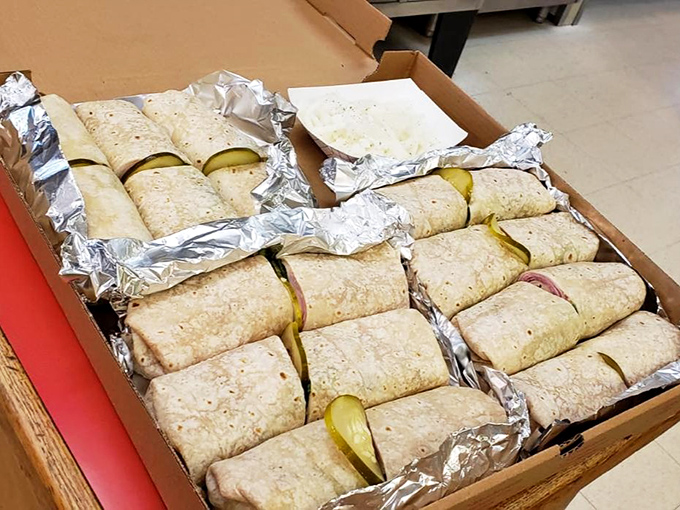 Burritos lined up like soldiers ready for deployment. Each one wrapped with precision and nestled beside pickle spears—an unexpected but welcome companion.