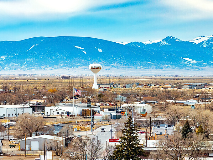 Alamosa spreads across the valley floor with its iconic water tower standing sentinel. Snow-capped mountains frame a town where retirement dollars stretch as far as the views.