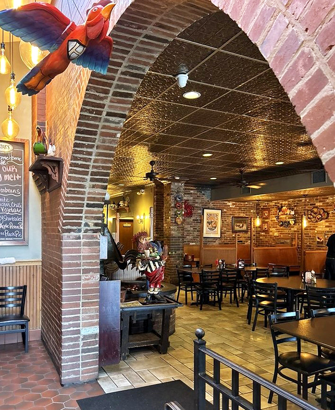 Brick archways frame dining rooms like chapters in a comfort food storybook. The colorful parrot adds a whimsical touch to this temple of fried deliciousness.