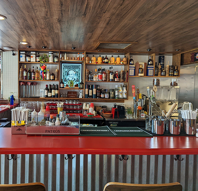 This isn't just a bar&mdash;it's a liquid laboratory where tropical concoctions come to life. The red counter adds just the right pop of color to this wood-and-metal masterpiece.