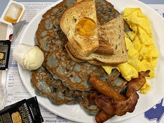 This breakfast plate demonstrates the beautiful chaos of eggs, bacon, blueberry pancakes, and toast living together in perfect harmony.