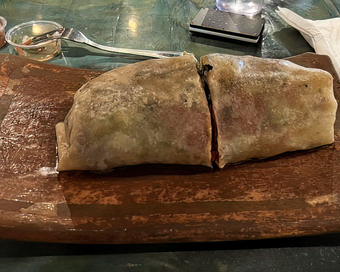 The burrito, sliced to reveal its treasure trove of fillings, sits like a satisfied diner who knows it's about to make someone very, very happy.
