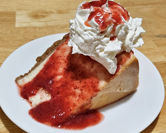 Cheesecake with strawberry topping and whipped cream that makes you wonder why we ever bother with birthday cakes when this masterpiece exists.