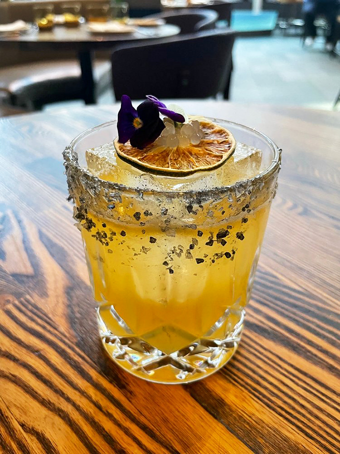This isn't just a cocktail&mdash;it's liquid sunshine with salt rim, dried citrus, and an edible flower that makes happy hour truly happy.