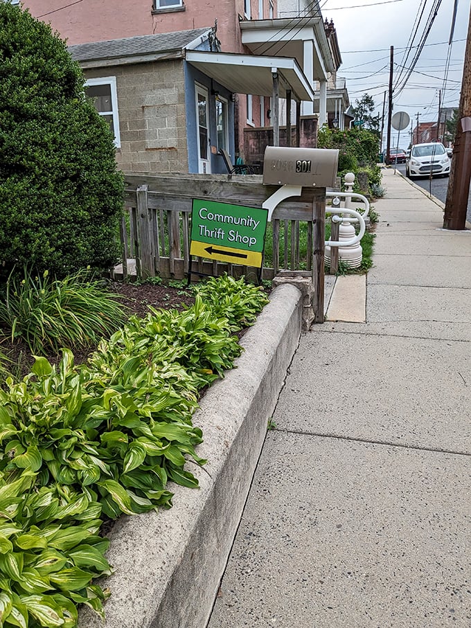 A welcoming sidewalk sign points the way, nestled among hostas and greenery&mdash;the first clue that community care extends beyond the shop's walls.