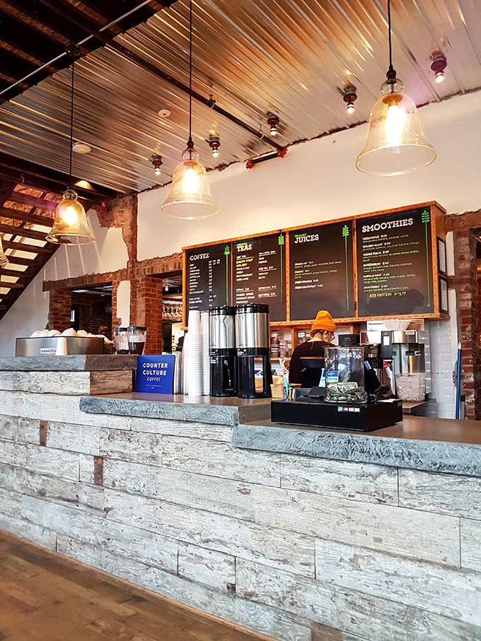 At the counter, coffee dreams become reality under pendant lights that make even waiting in line feel like you're part of something special.