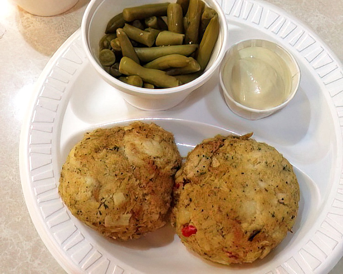 Crab cakes served with green beans and sauce—simple food done right. In an age of culinary complexity, there's something refreshing about straightforward perfection.
