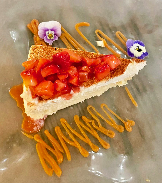 Cheesecake living its best life with berry topping and edible flowers&mdash;dessert that's dressed better than most people at the restaurant.