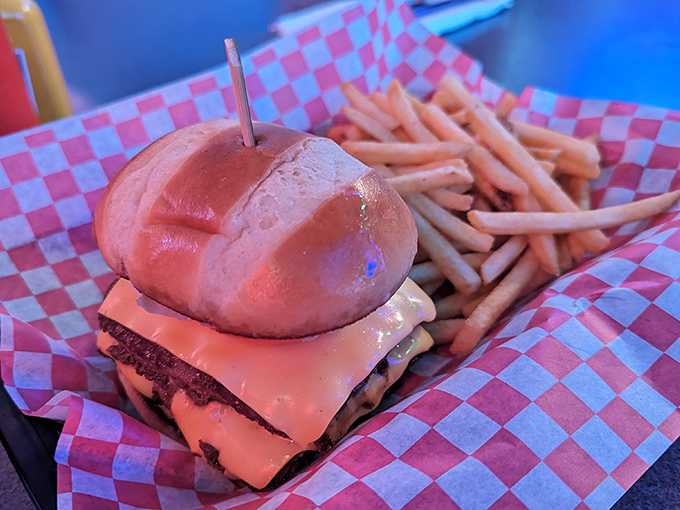 A burger that requires both hands and a strategy. The toothpick isn't holding it together&mdash;it's a flagpole claiming this mountain of deliciousness for America. 