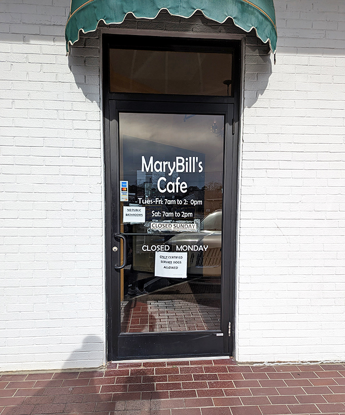 The entrance tells you everything you need to know: unpretentious, welcoming, and with hours that respect the sanctity of a good Sunday rest. The green awning is just a bonus.