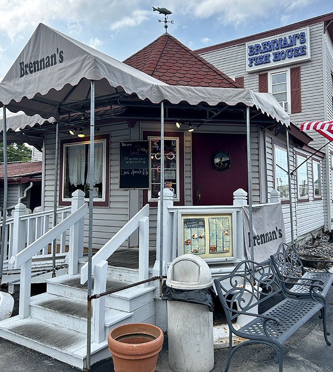 The white steps and striped awning welcome you like an old friend. That fish weathervane on top isn't just decoration—it's a promise of what awaits inside.