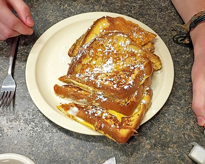 French toast that looks like it's been dipped in liquid gold. That powdered sugar dusting is just showing off at this point.