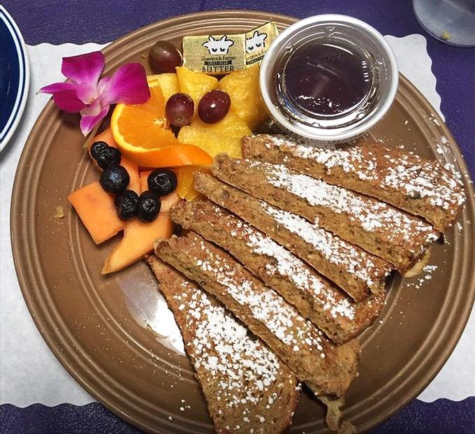 French toast that's dressed for success with powdered sugar, fresh fruit, and what appears to be the world's most tempting side of syrup.