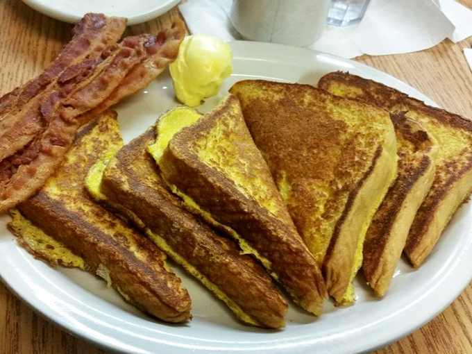 French toast that's achieved that perfect golden-brown exterior while maintaining its custardy soul, served with bacon that knows exactly what it's doing.
