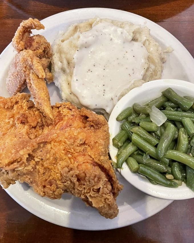 The holy trinity of comfort: fried chicken, mashed potatoes with gravy, and green beans. This plate doesn't just feed your body&mdash;it nourishes your soul.