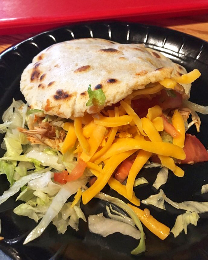 This gordita doesn't just sit on the plate &ndash; it commands attention with its golden exterior and colorful toppings. Handheld happiness at its finest.