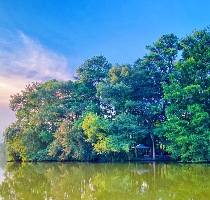 Sunset casts a golden glow across the pond, where hidden gazebos peek through lush greenery&mdash;nature's perfect ending to a perfect day.