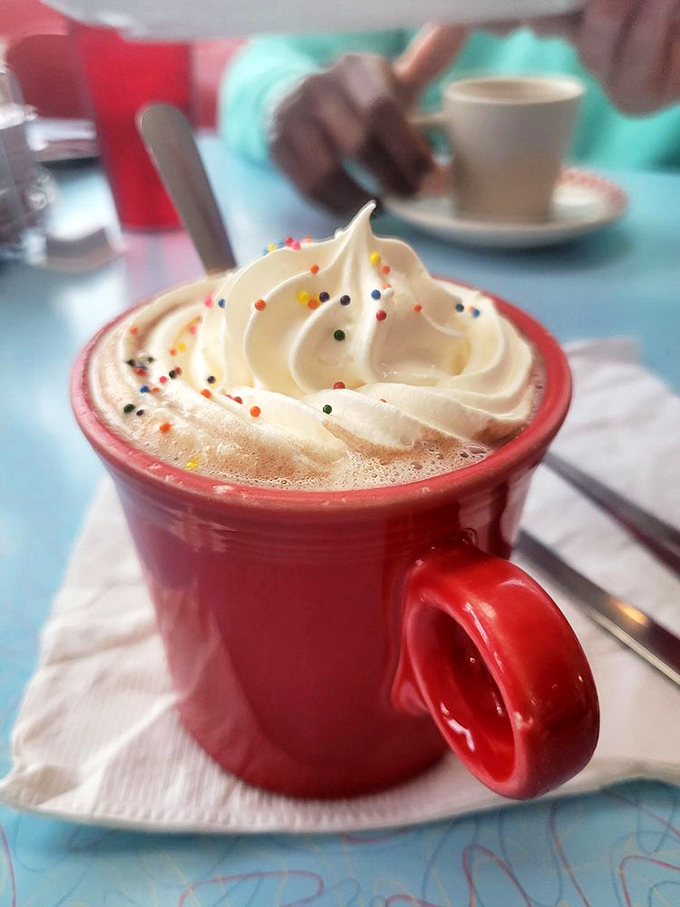 Hot chocolate that wears whipped cream like a jaunty beret. Those sprinkles aren't decoration&mdash;they're confetti for your taste buds.