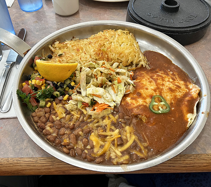 Huevos Rancheros served on a sizzling platter&mdash;a breakfast fiesta where crispy hash browns, beans, and ranchero sauce throw the morning's best party.