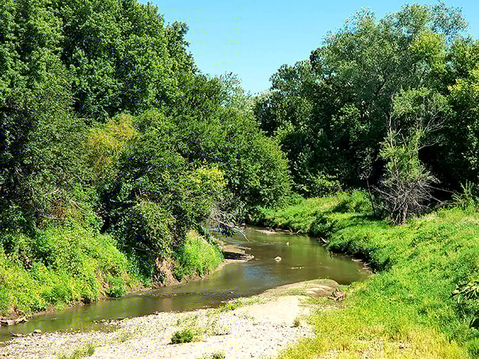 Independence Creek meanders through lush greenery, a reminder that nature's finest amenities in Atchison come without a monthly subscription fee.