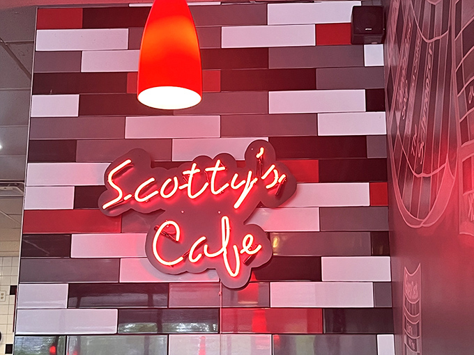 The signature neon "Scotty's Caf&eacute;" sign against colorful subway tiles serves as a beacon of hope for the hungry and a promise of satisfaction to come.