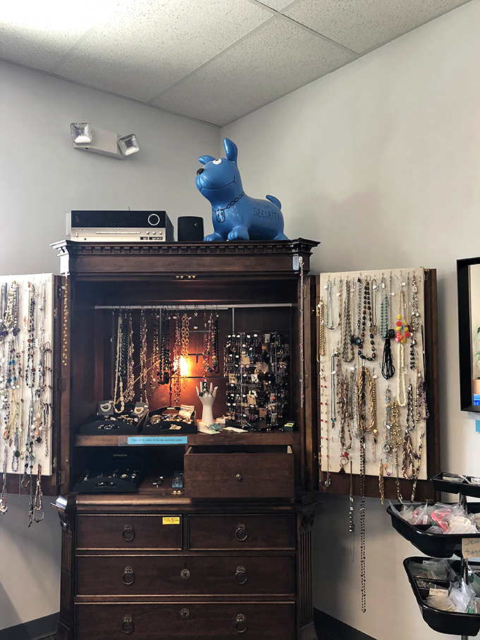 A repurposed armoire becomes jewelry central, topped with a blue mascot keeping watch over necklaces that once adorned other necks.