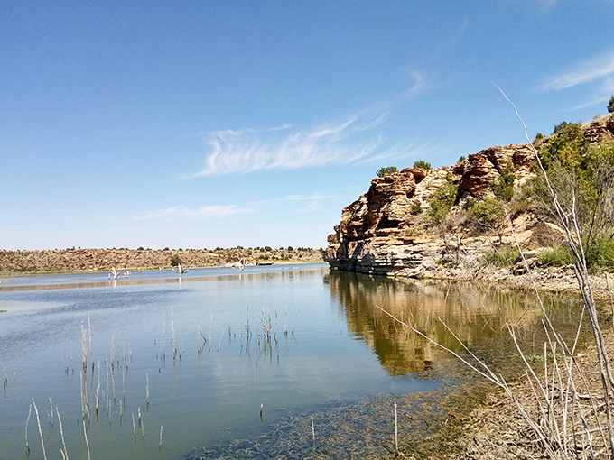 Lake waters mirror dramatic rock formations, creating reflections that look suspiciously better than most people's vacation photos.