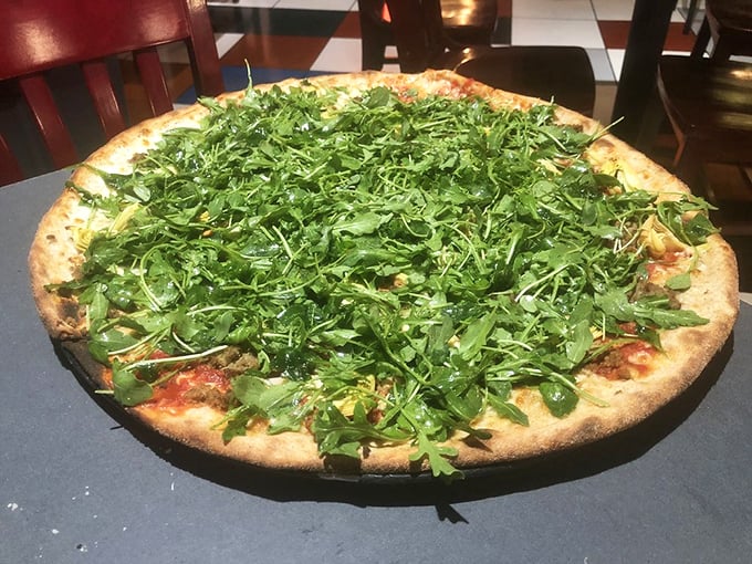 The arugula on this pizza isn't just a topping&mdash;it's a lush green canopy. Beneath that peppery forest lies a treasure of savory delights waiting to be discovered.