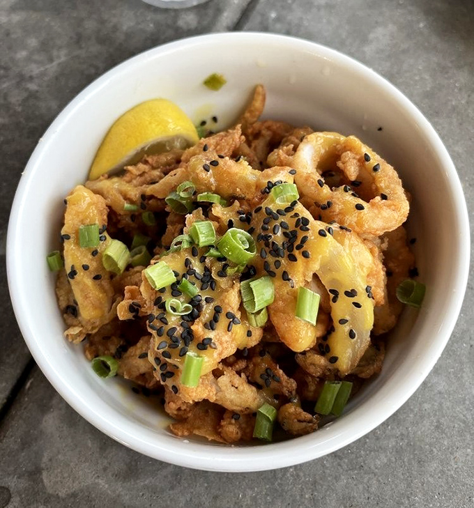 Calamari that defies the rubbery reputation of lesser versions. These golden rings, kissed with scallions and sesame, are what other appetizers aspire to be.