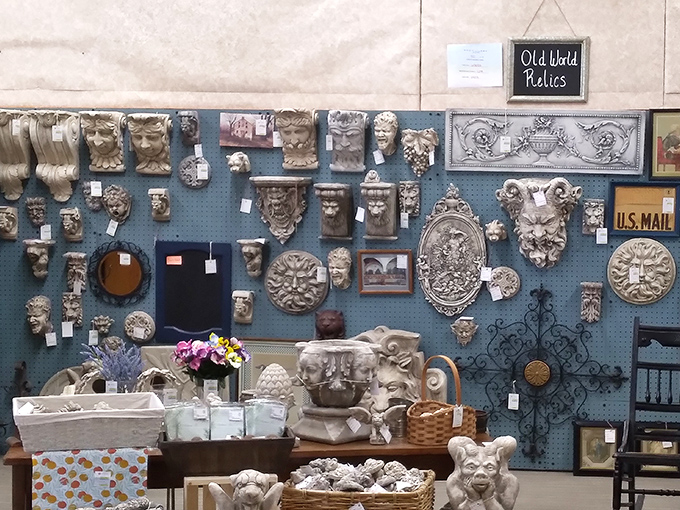 Classical faces and ornate architectural pieces cover this wall, transforming ordinary booth space into an antiquities museum corner display.